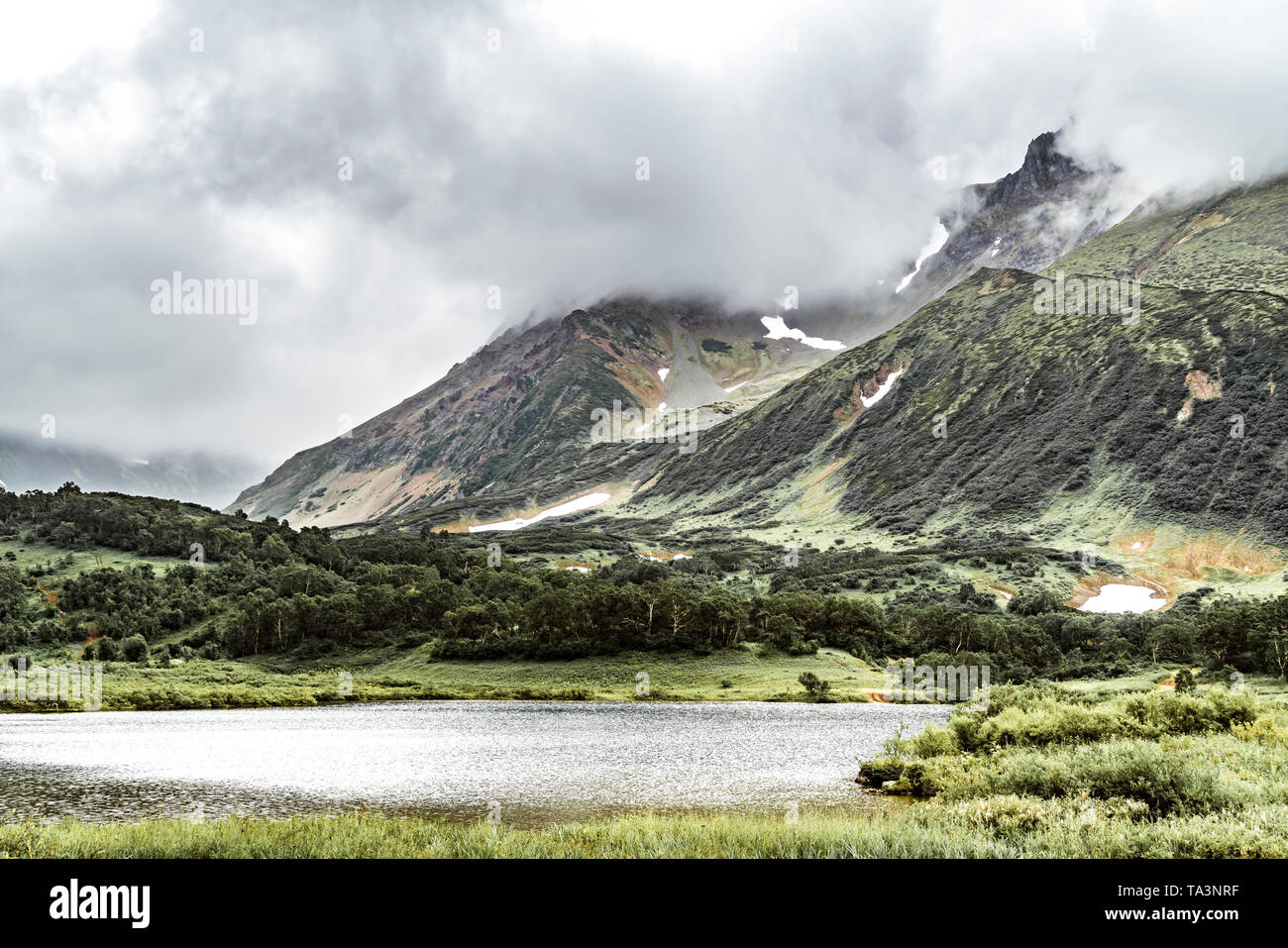 Volcanic landscape with green plains and lake on Kamchatka peninsula ...