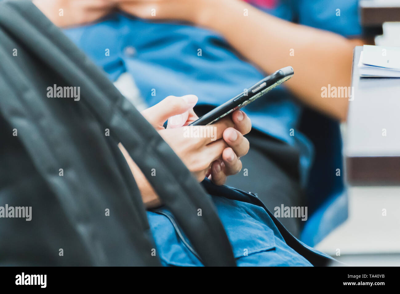 Close up of Asian student using his phone during the class under the ...