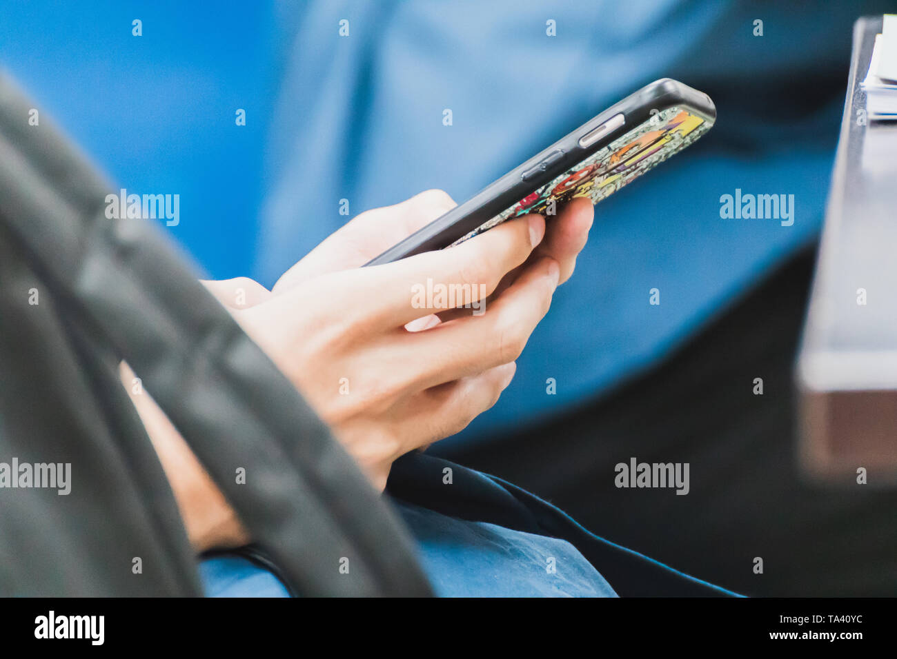 Close up of Asian student using his phone during the class under the ...
