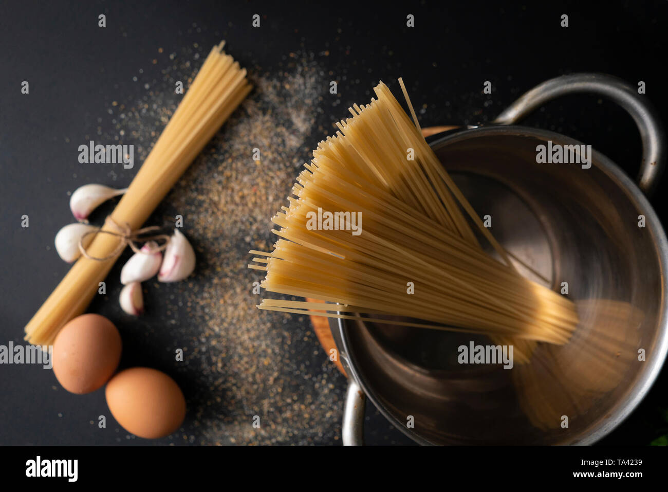 top view of raw hard spaghetti in a metal pot, boiling water ...