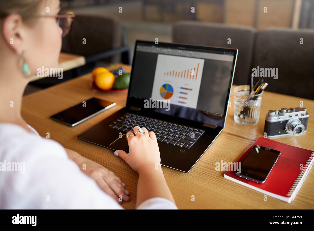Close-up rear view of young business or student woman working at cafe ...