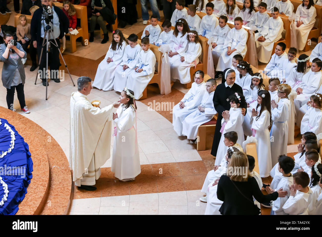 Zagreb, Croatia - May 5, 2019 : The priest gives first communion to the ...