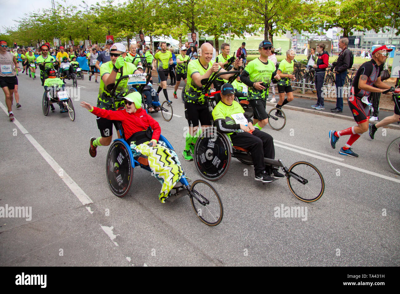 Group of marathon runners pushing running wheel chairs with disabled ...