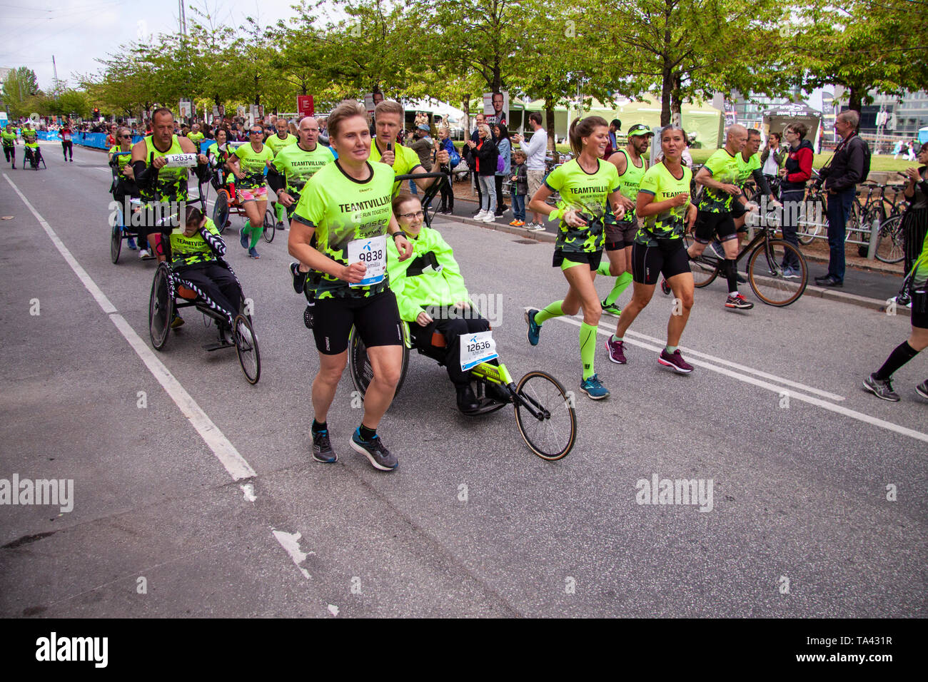Group of marathon runners pushing running wheel chairs with disabled ...