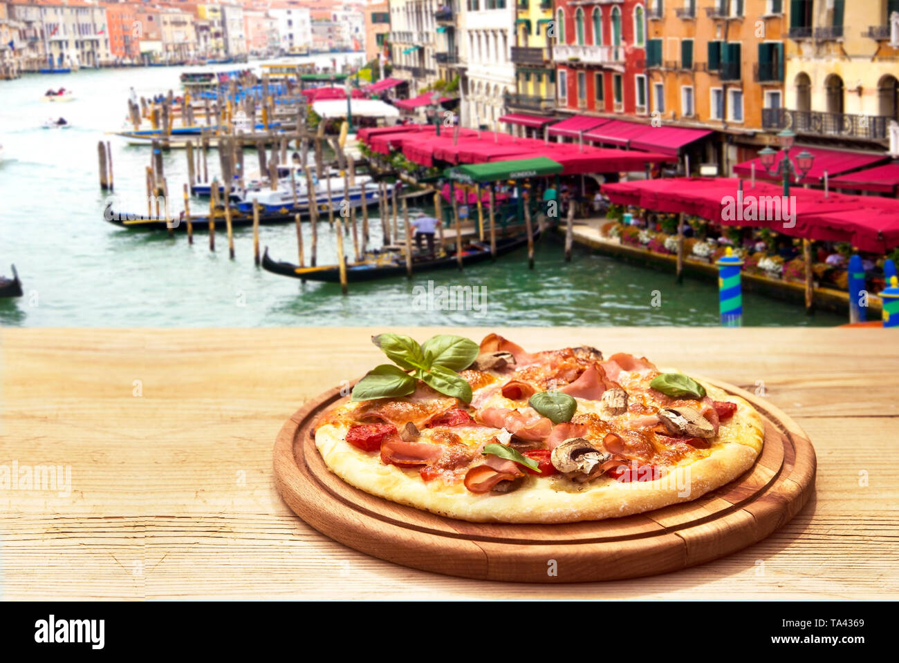 Rustic pizza on wooden table with Venice background Stock Photo - Alamy