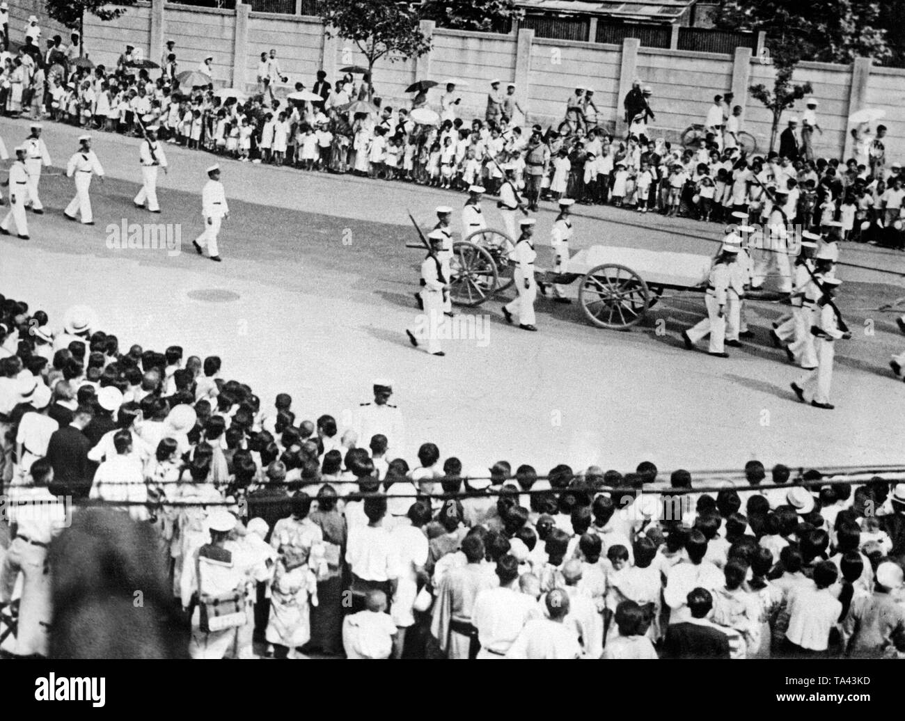 On September 23, 1937, people line a street in Tokyo to pay tribute to ...
