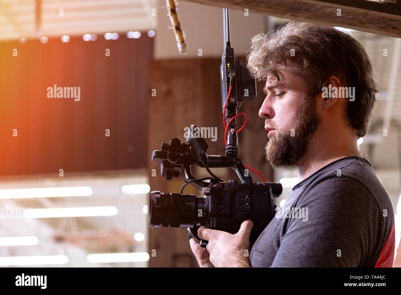 Videographer shooting a film or a television program in a studio with a ...