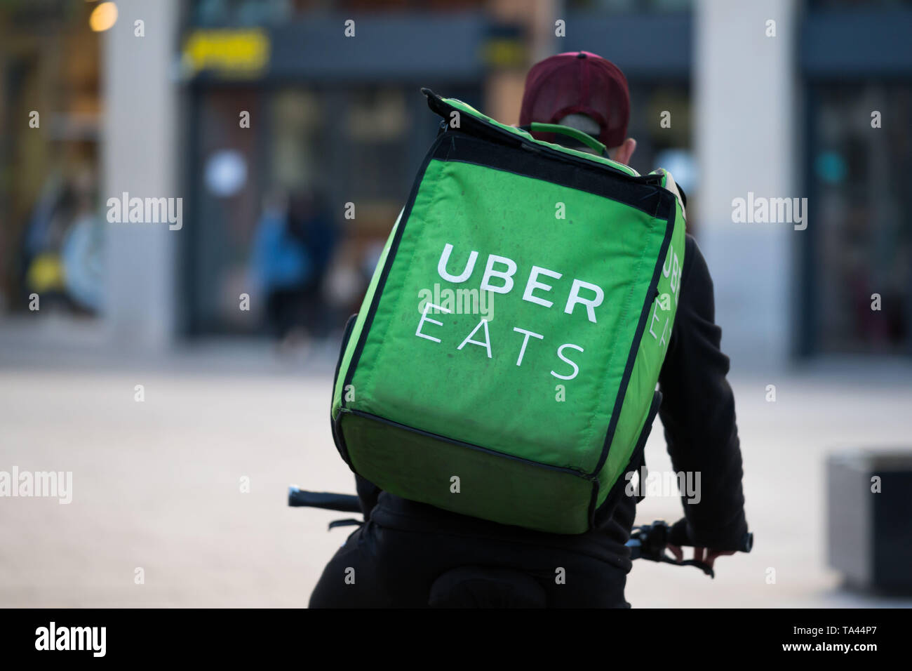 An Uber Eats rider cycles through Cardiff city centre Stock Photo - Alamy
