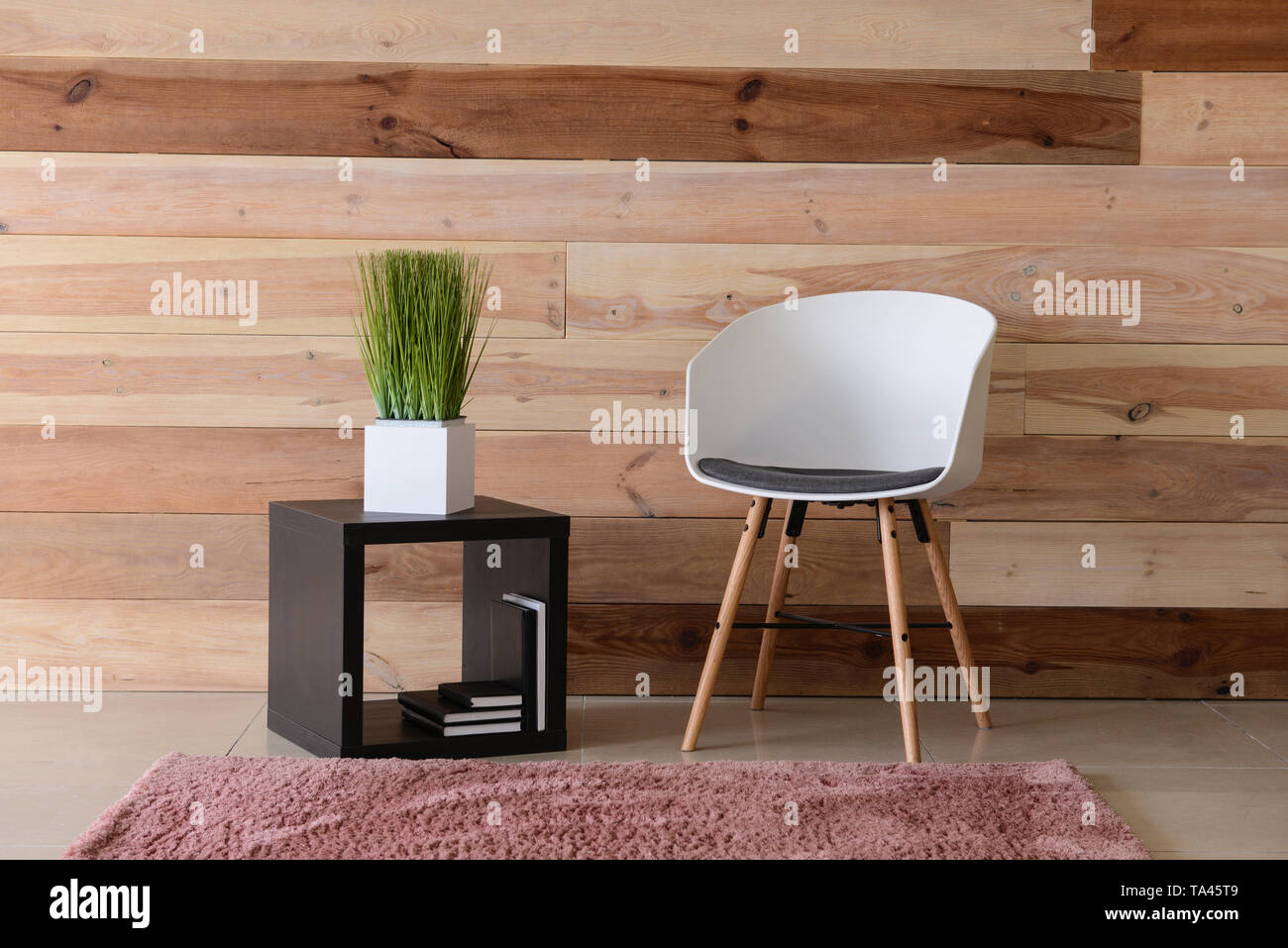 Interior of modern room with chair near wooden wall Stock Photo - Alamy