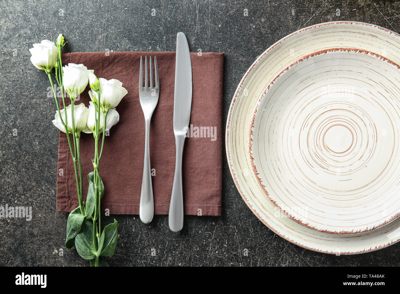 Beautiful table setting with flowers on dark background Stock Photo - Alamy