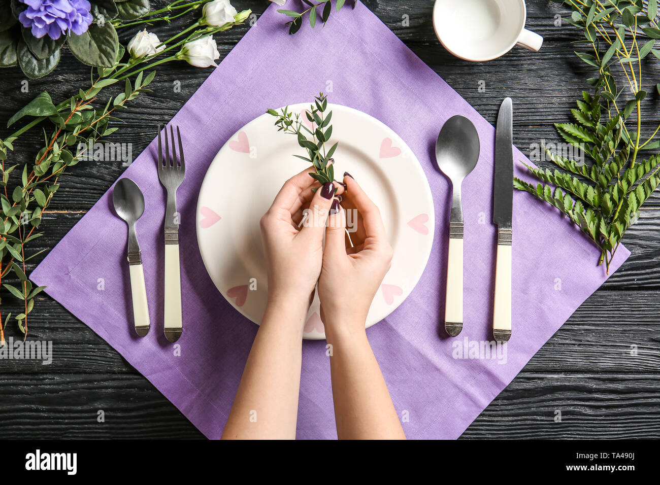 Woman setting a table for dinner Stock Photo - Alamy
