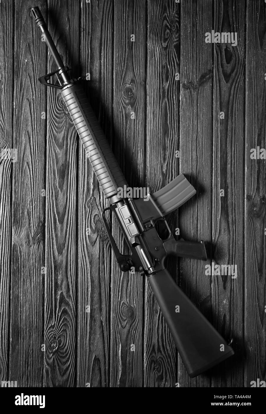 Assault rifle on wooden background Stock Photo - Alamy