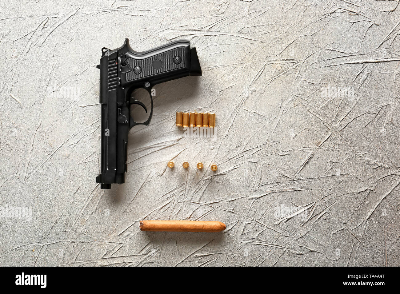 Pistol, bullets and cigar on light background Stock Photo - Alamy
