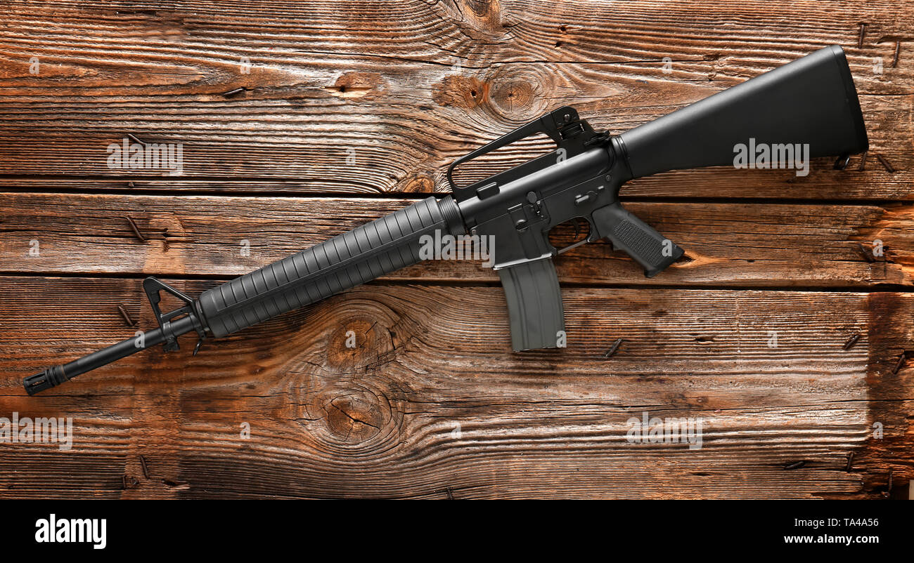 Assault rifle on wooden background Stock Photo - Alamy