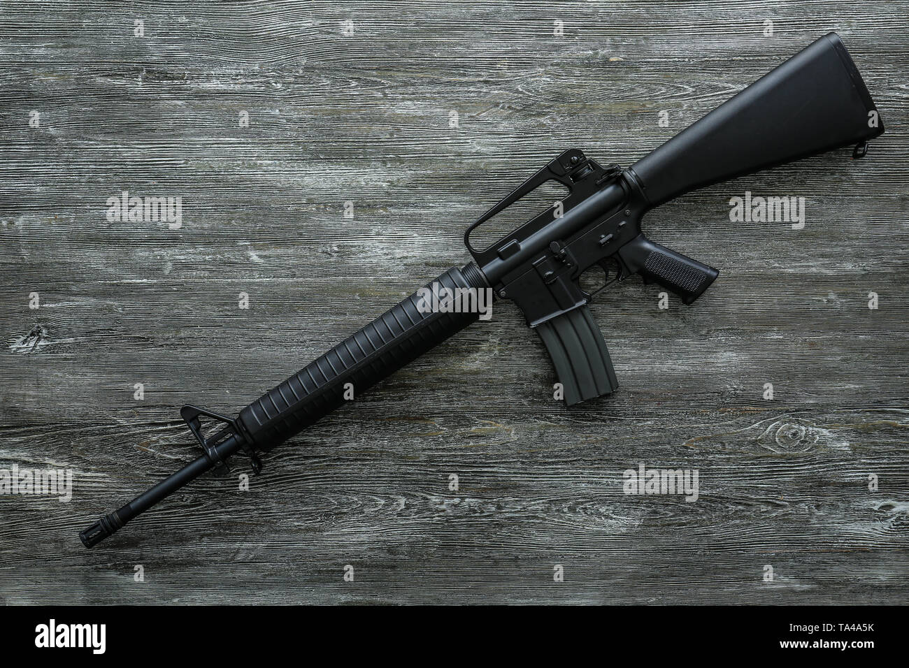 Assault rifle on wooden background Stock Photo - Alamy