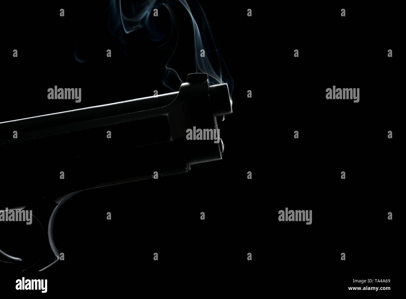 Silhouette of smoking pistol on dark background Stock Photo - Alamy