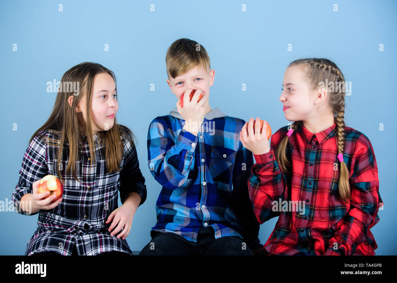 Group cheerful teenagers having fun and eating apples. Healthy dieting ...