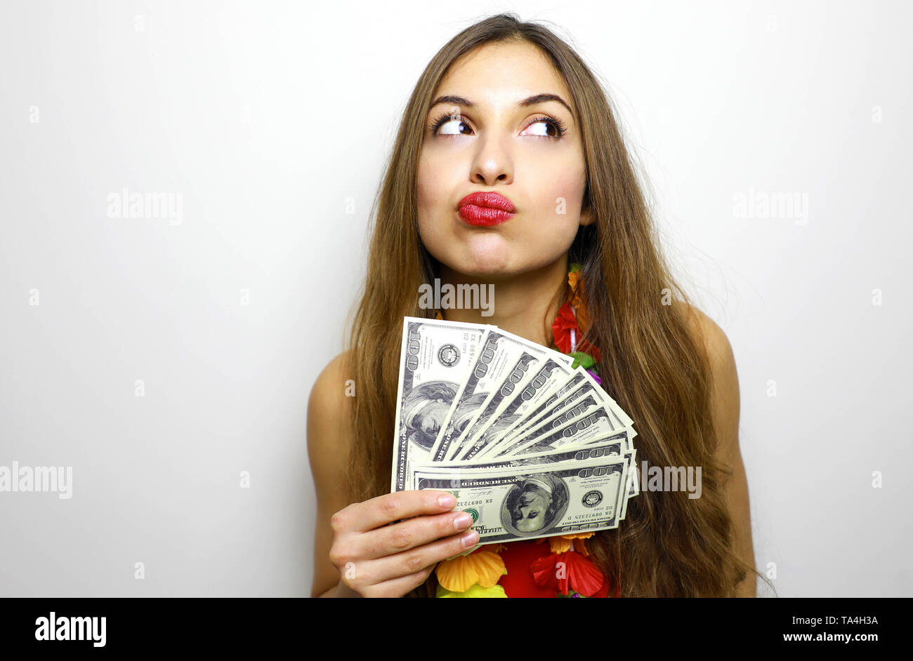 Beautiful woman thinking how to spend her money Stock Photo - Alamy