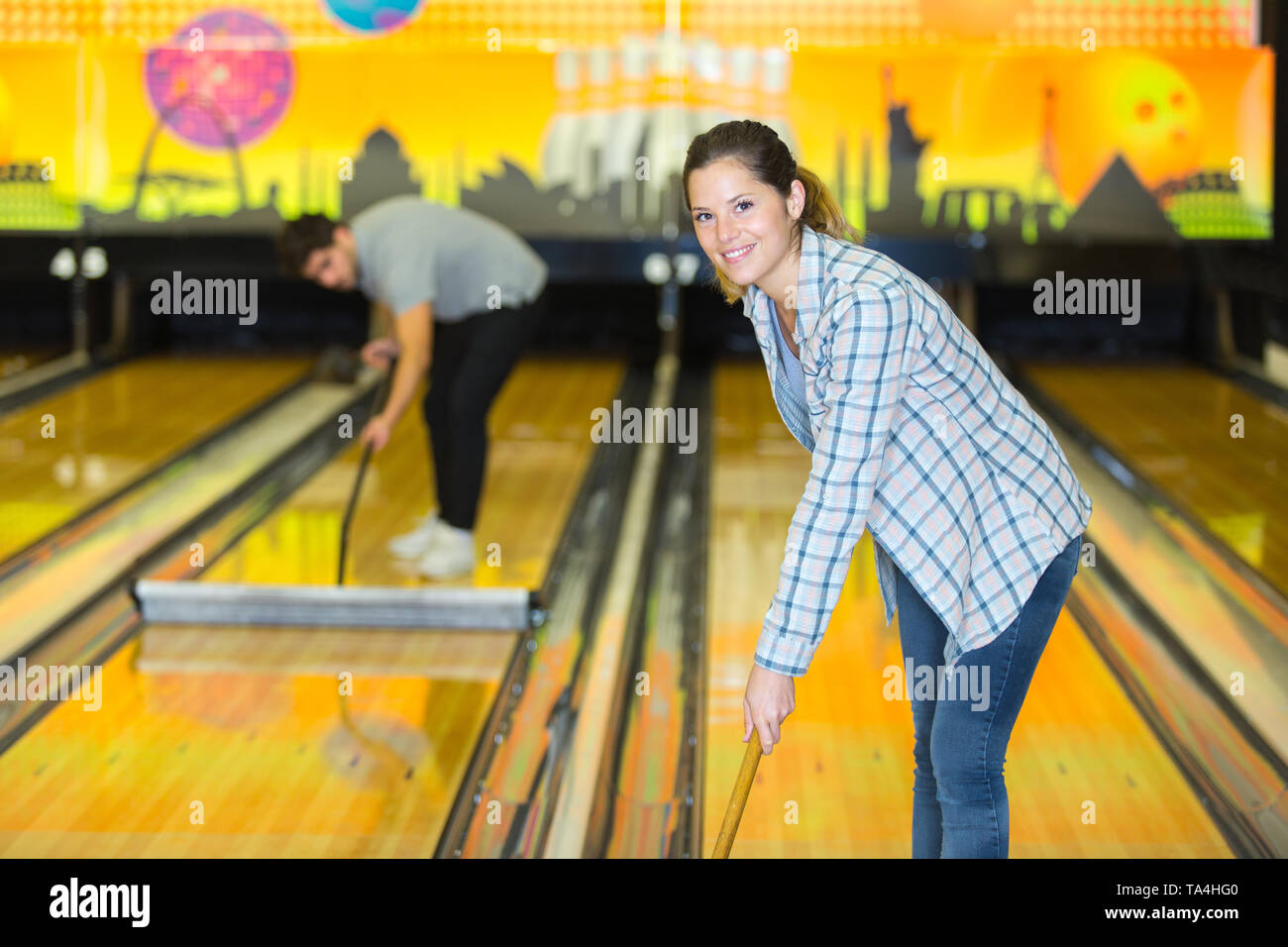 bowling center employees cleaning the area Stock Photo - Alamy