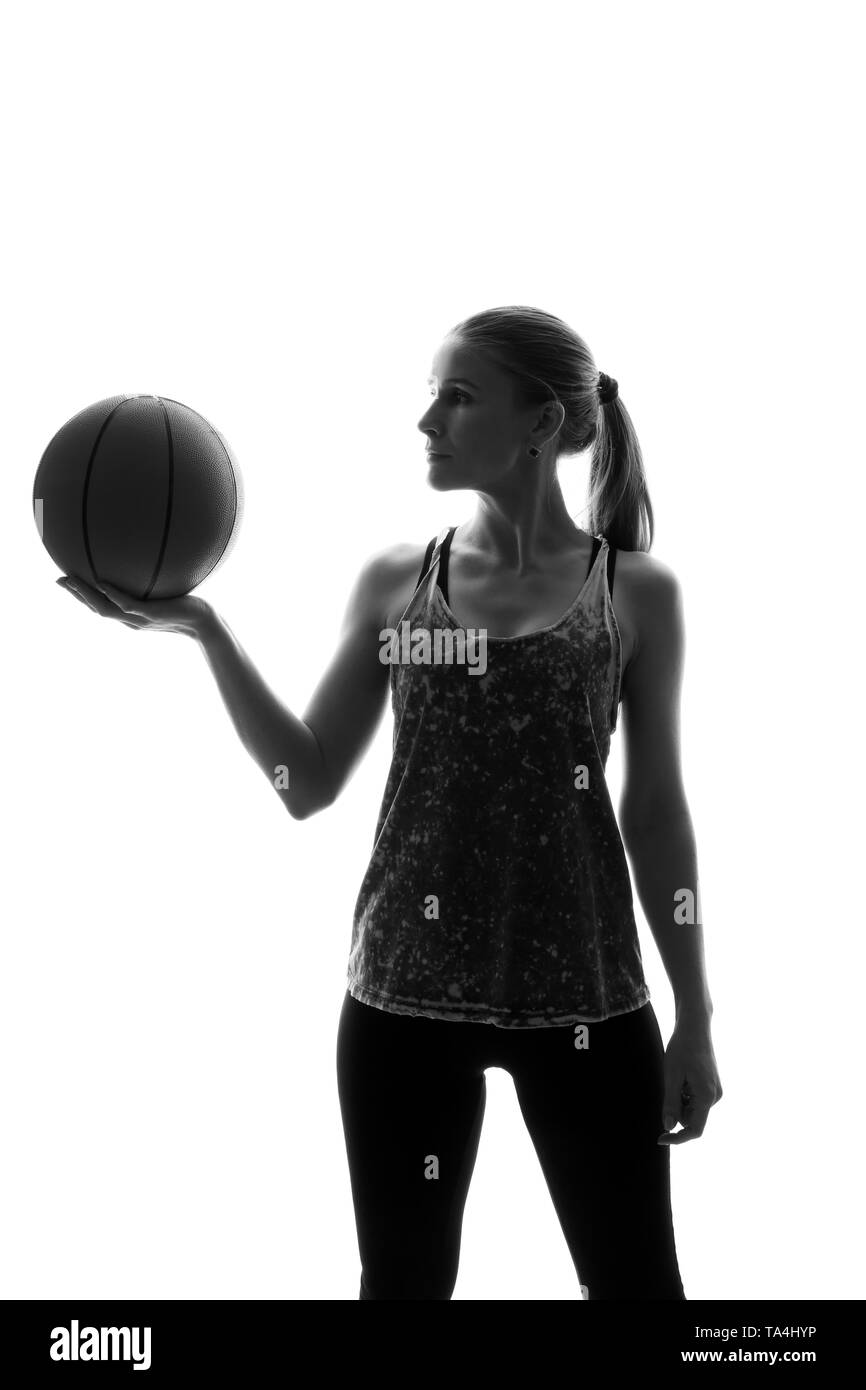 Portrait of beautiful woman playing basketball on white background ...