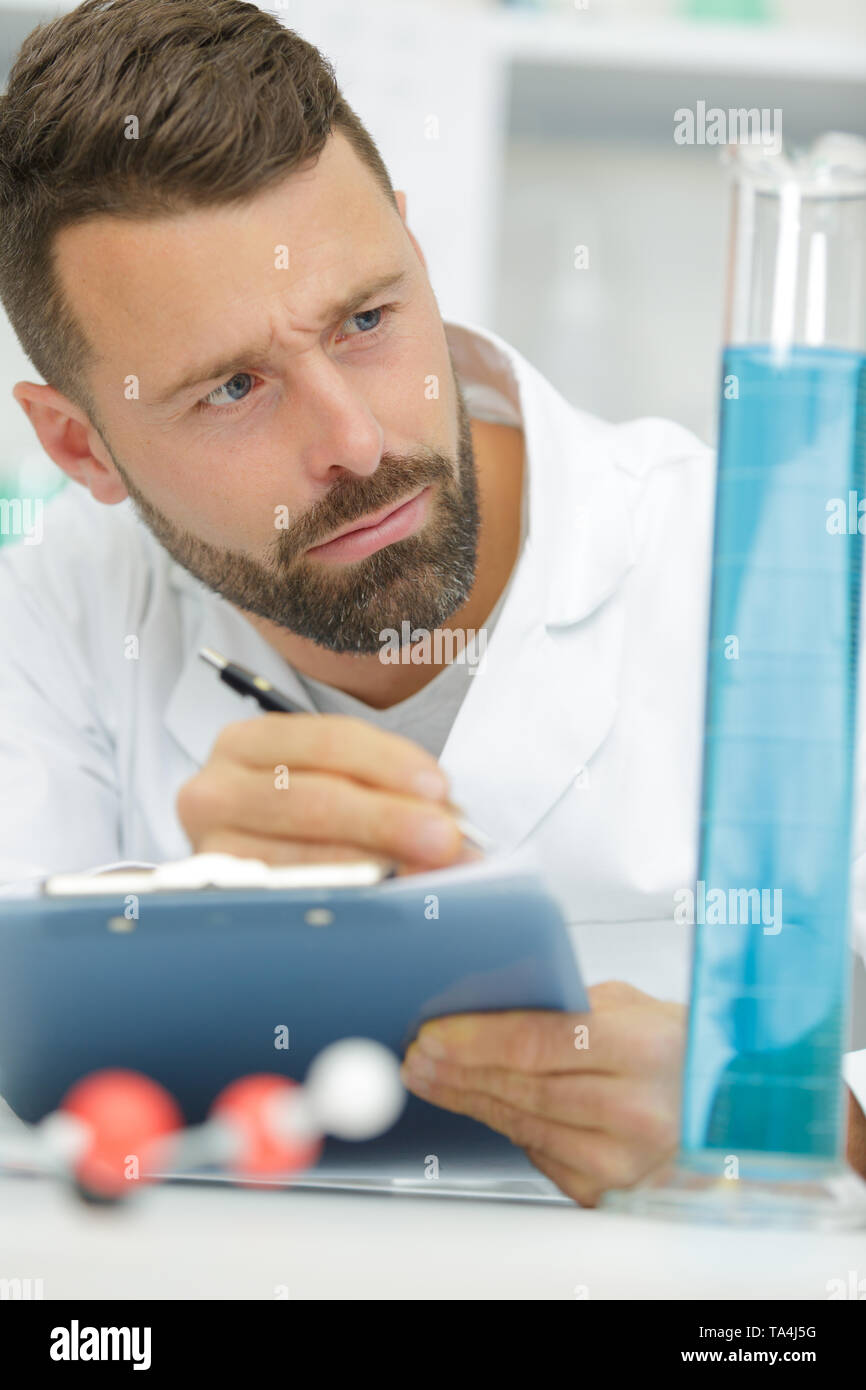scientist examining jar with liquid sample Stock Photo - Alamy