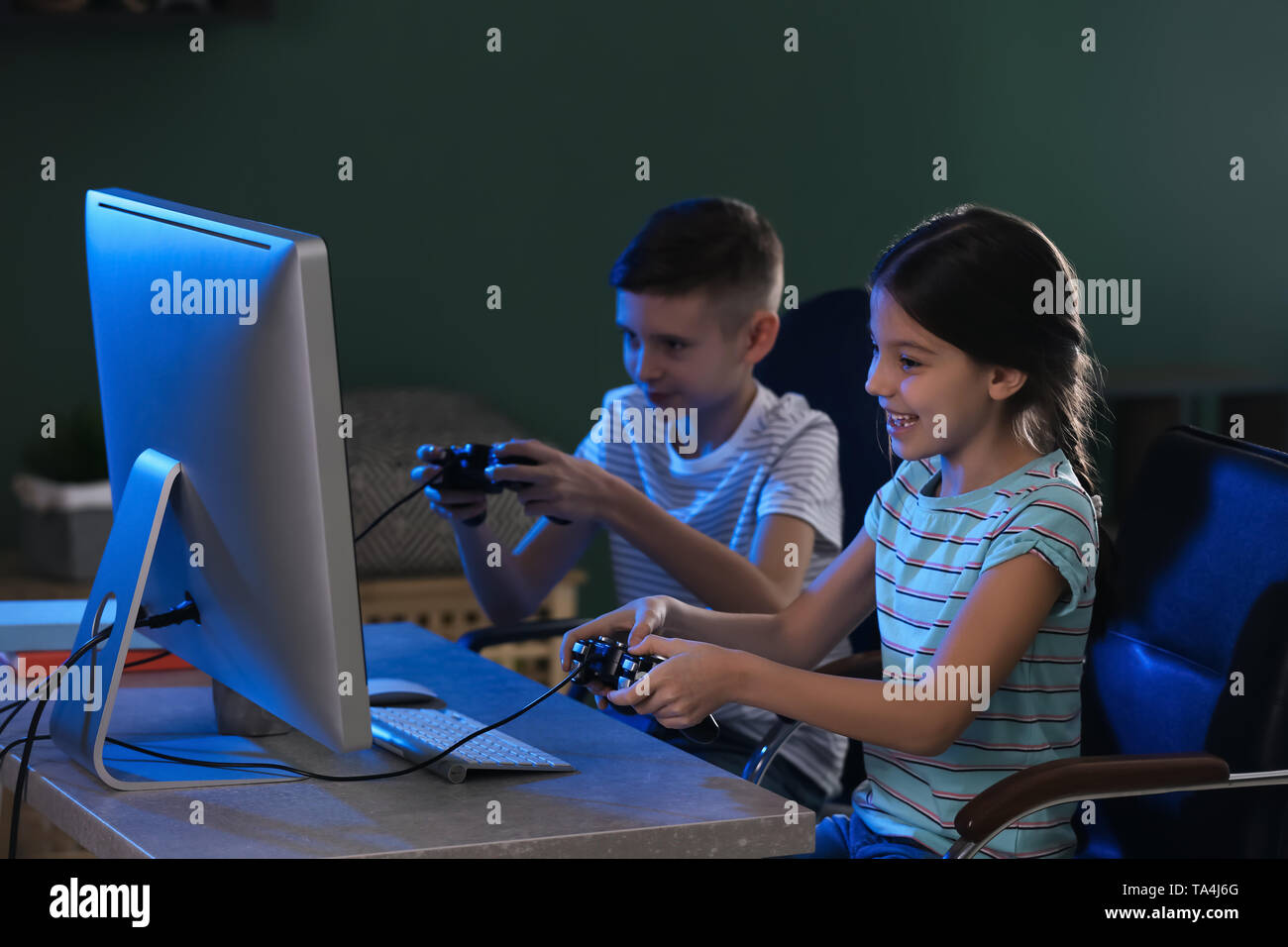 Cute little children playing computer game at home Stock Photo - Alamy