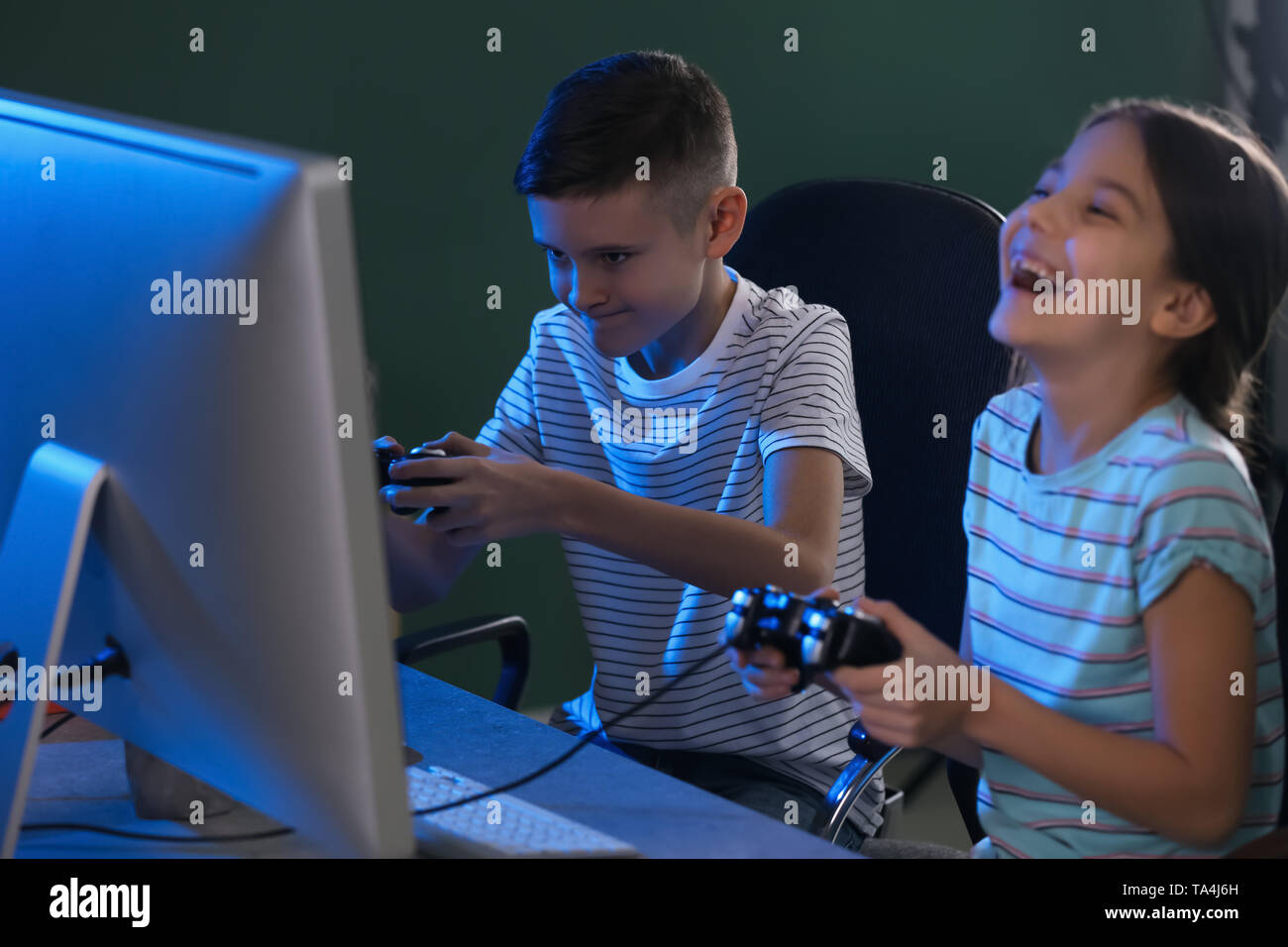 Cute little children playing computer game at home Stock Photo - Alamy