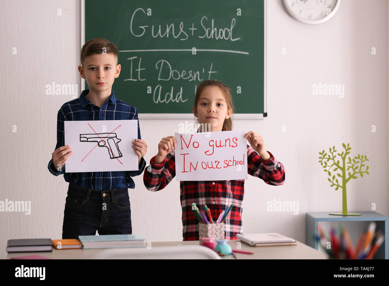 Cute little children with agitation posters in classroom. Concept of ...
