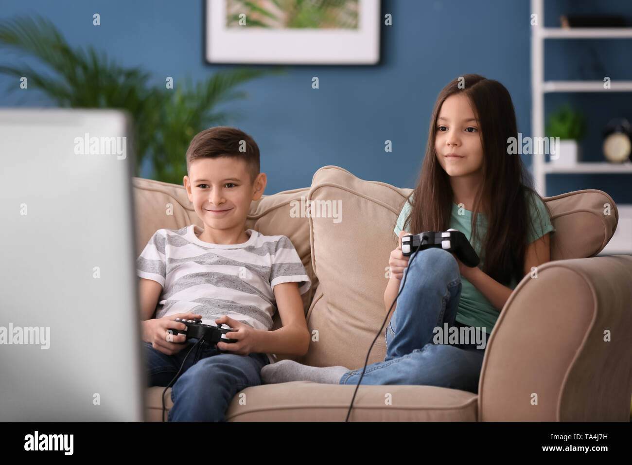 Cute little children playing computer game at home Stock Photo - Alamy