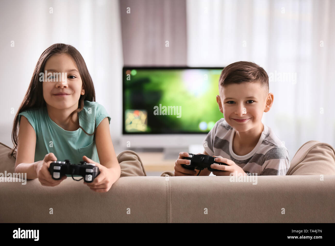 Cute little children playing computer game at home Stock Photo - Alamy