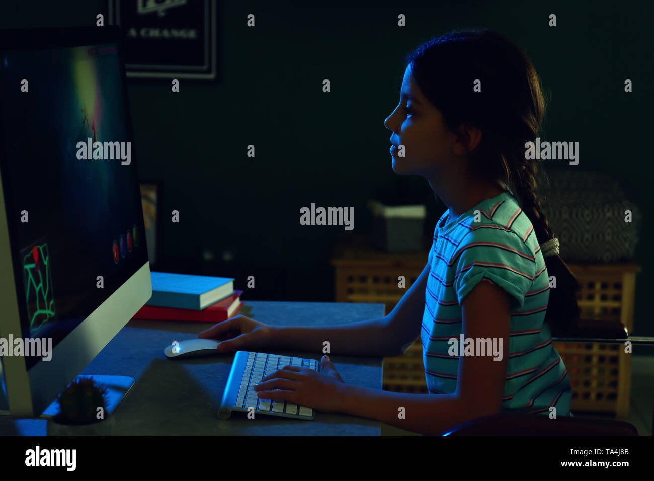 Cute little girl playing computer game at home Stock Photo - Alamy