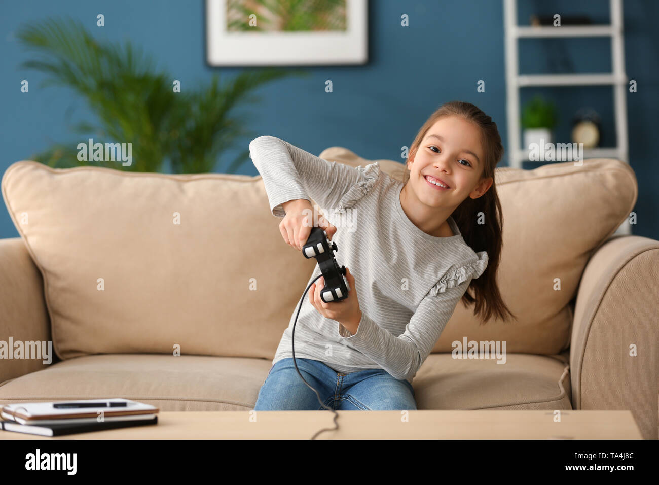 Cute little girl playing computer game at home Stock Photo - Alamy