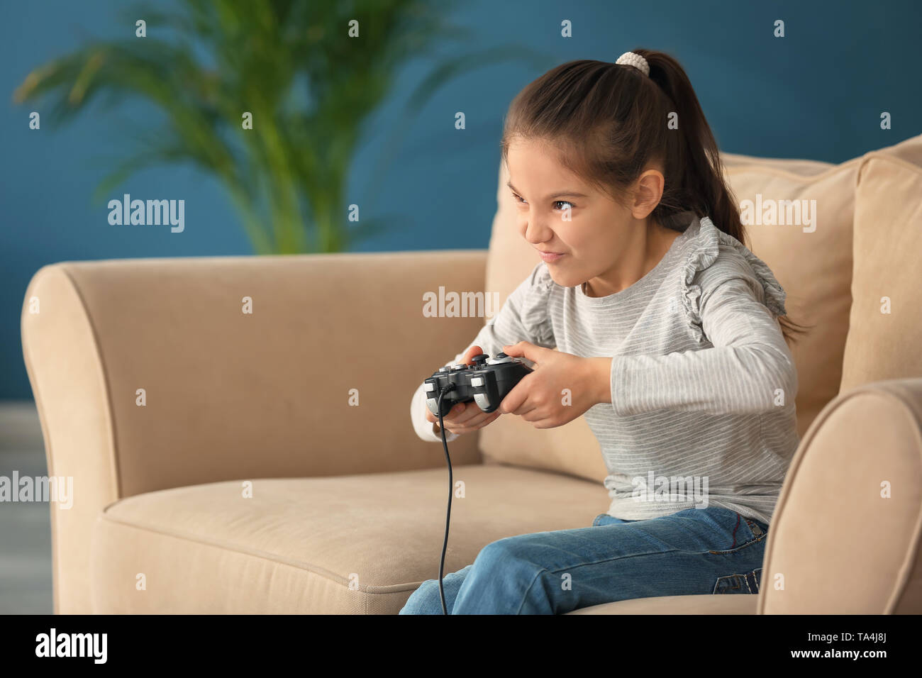 Emotional little girl playing computer game at home Stock Photo - Alamy