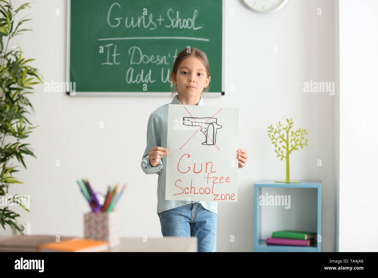 Cute little girl with agitation poster in classroom. Concept of school ...