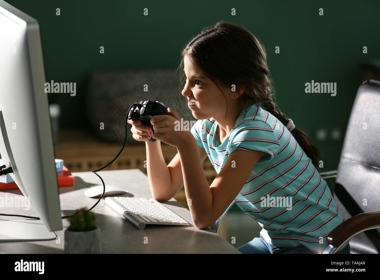 Emotional little girl playing computer game at home Stock Photo - Alamy