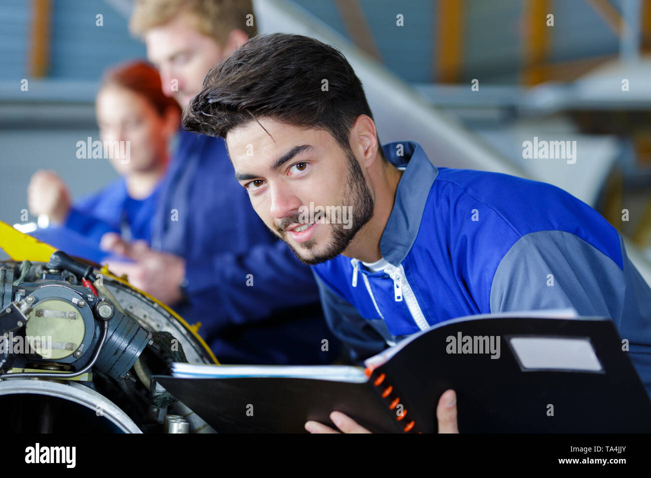 apprentice mechanic holding engine block in garage Stock Photo - Alamy