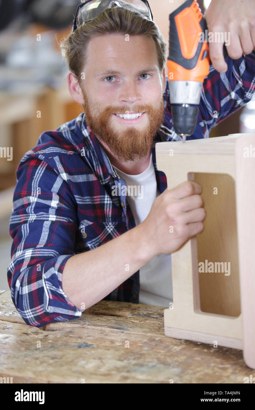 man drilling furniture wood Stock Photo - Alamy