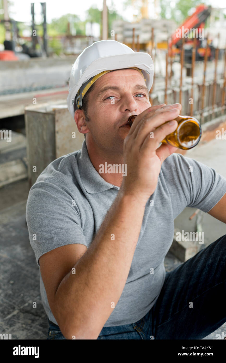 drunk builder drinking beer from a bottle Stock Photo - Alamy