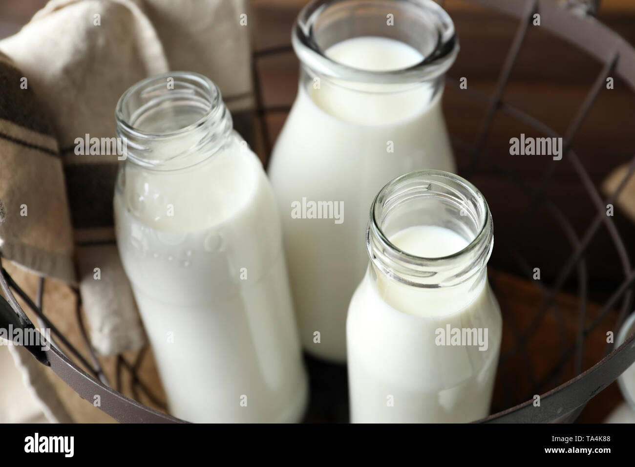 Basket with bottles of fresh tasty milk on table Stock Photo - Alamy