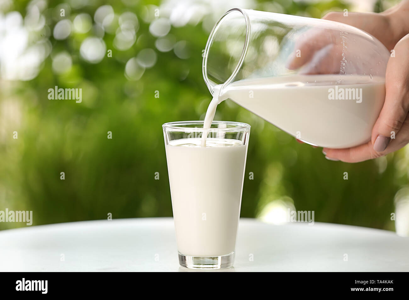 Woman pouring fresh milk glass hi-res stock photography and images - Alamy