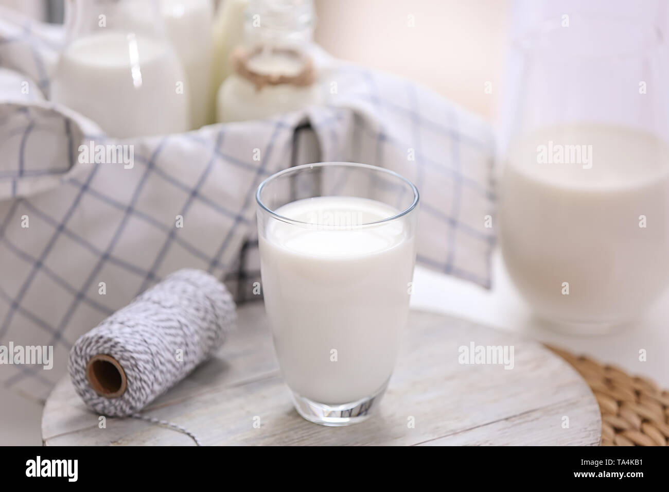 Glass of fresh milk on light table Stock Photo - Alamy