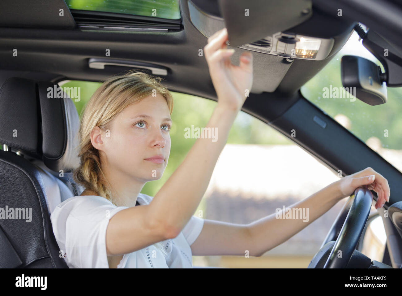 woman looking in rear view mirror of car Stock Photo - Alamy