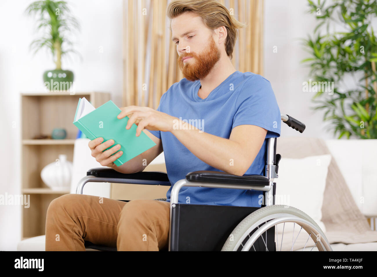 disabled man on wheelchair reading book with thoughtful look Stock ...