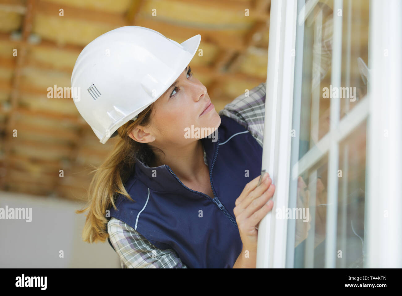 female builder is checking a window Stock Photo - Alamy