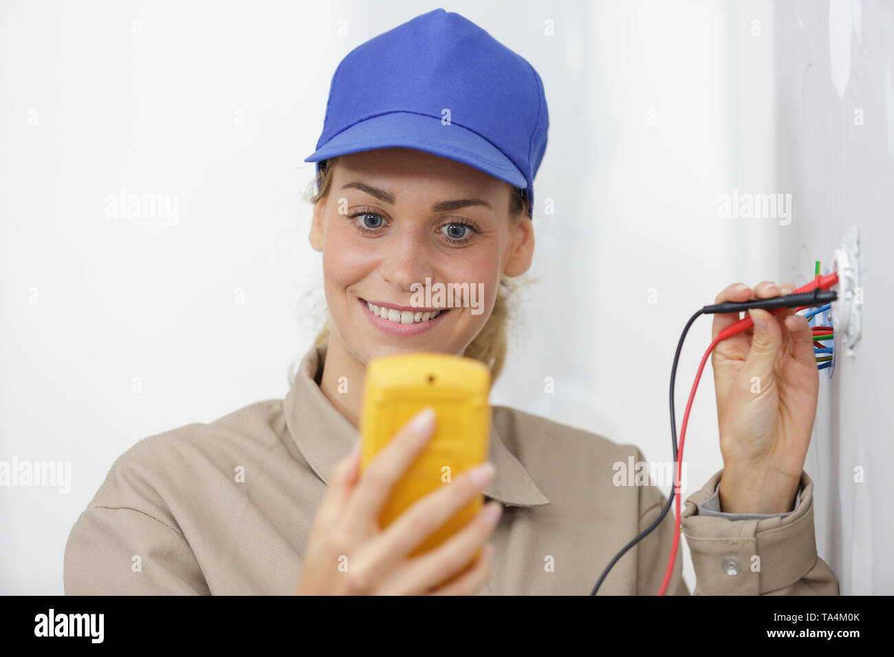 happy female electrician testing a wall socket Stock Photo - Alamy