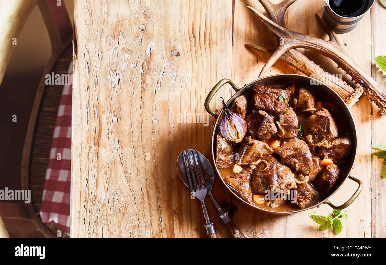 Tasty spicy gourmet venison goulash served in a small copper pot with ...