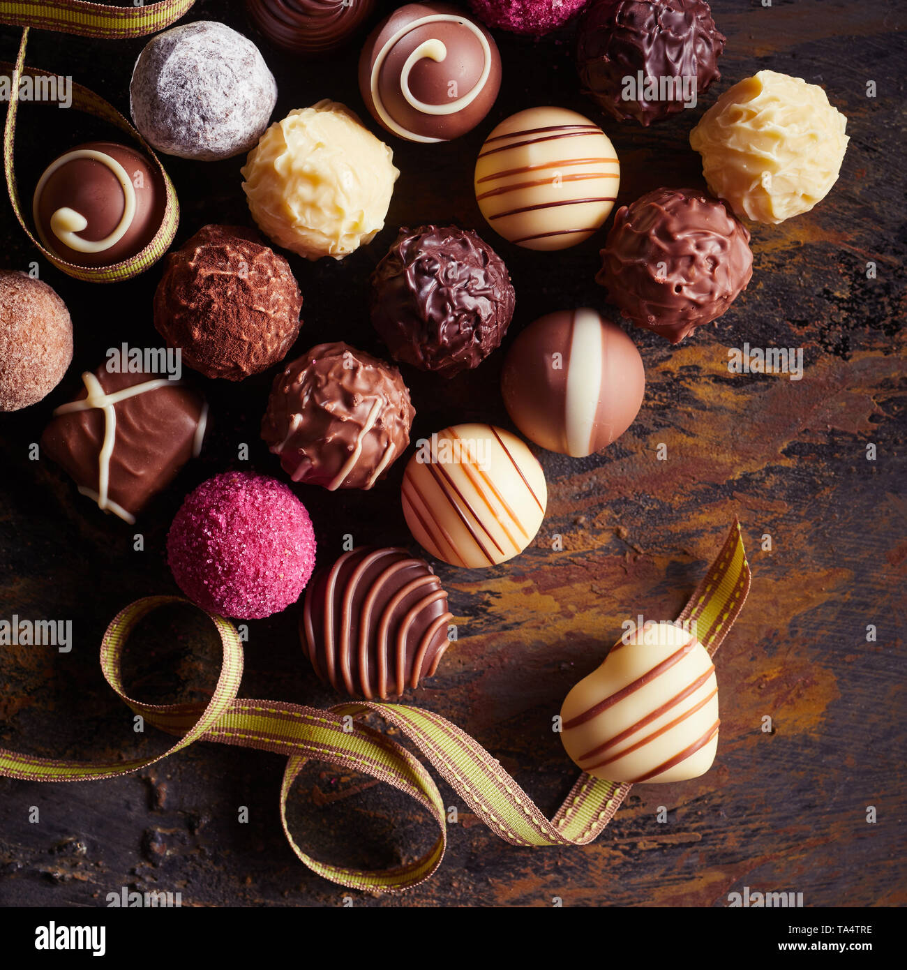 Heart shaped romantic chocolate praline on a twirled gold ribbon ...