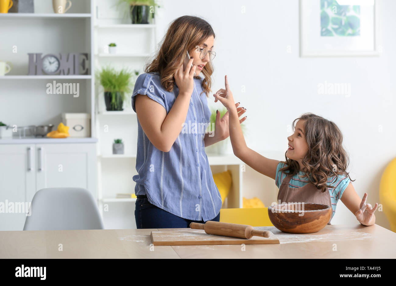 Mom multitasking in kitchen hi-res stock photography and images - Alamy