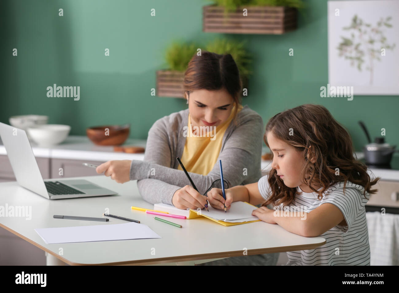 Busy mother with daughter working at home Stock Photo - Alamy