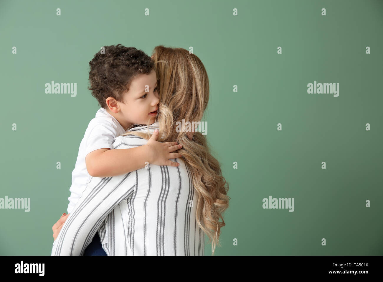 Portrait of cute little boy with mother on color background Stock Photo ...